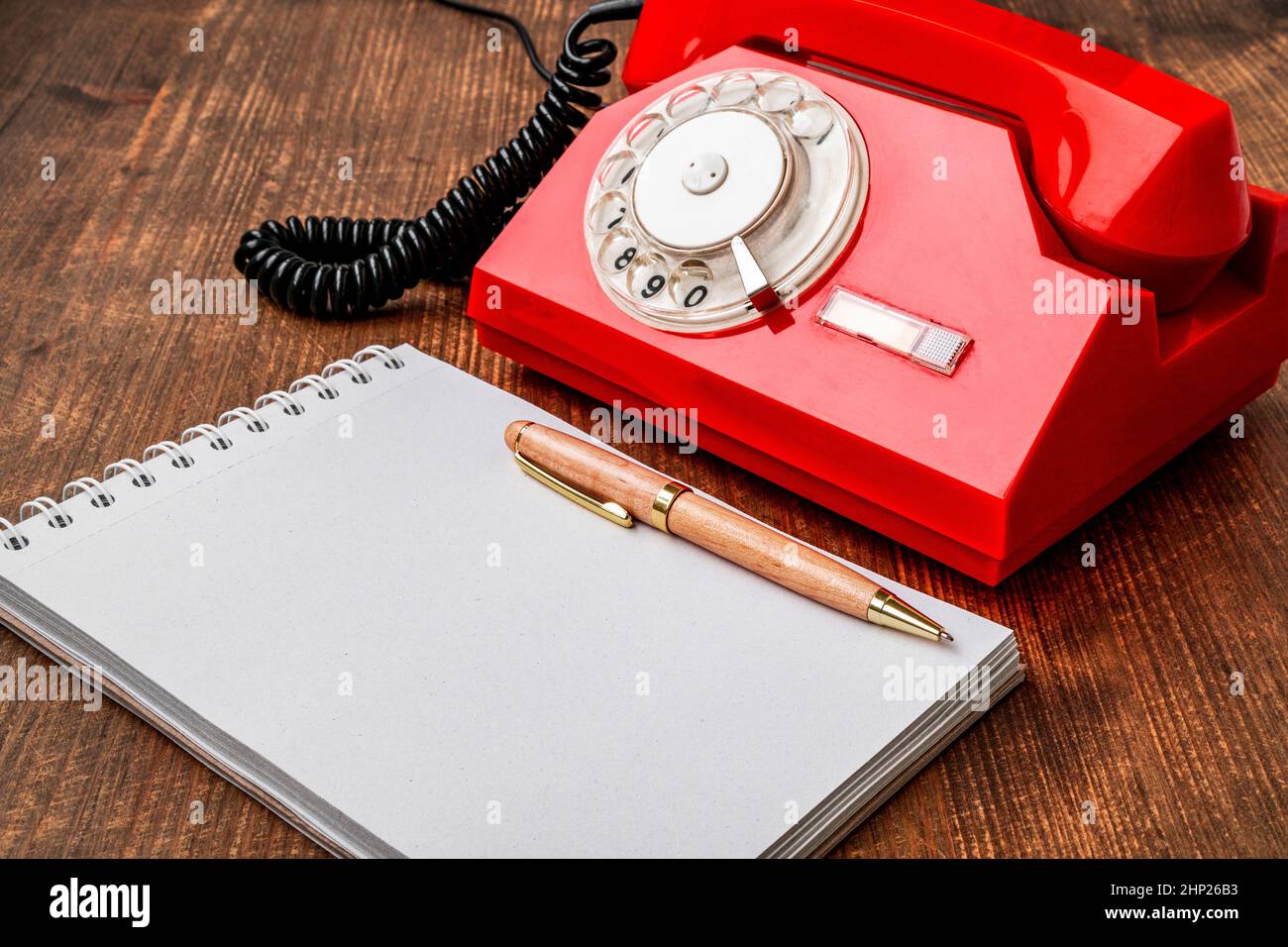 Retro old fashioned rotary phone and notebook on wooden table. Business ...