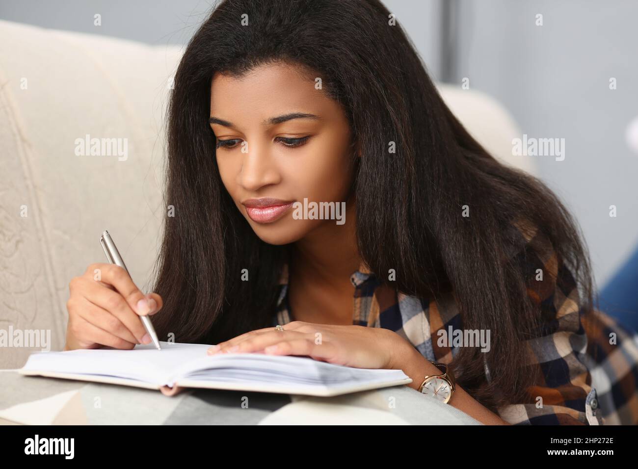 girl on the sofa makes notes in the book, close-up Stock Photo - Alamy