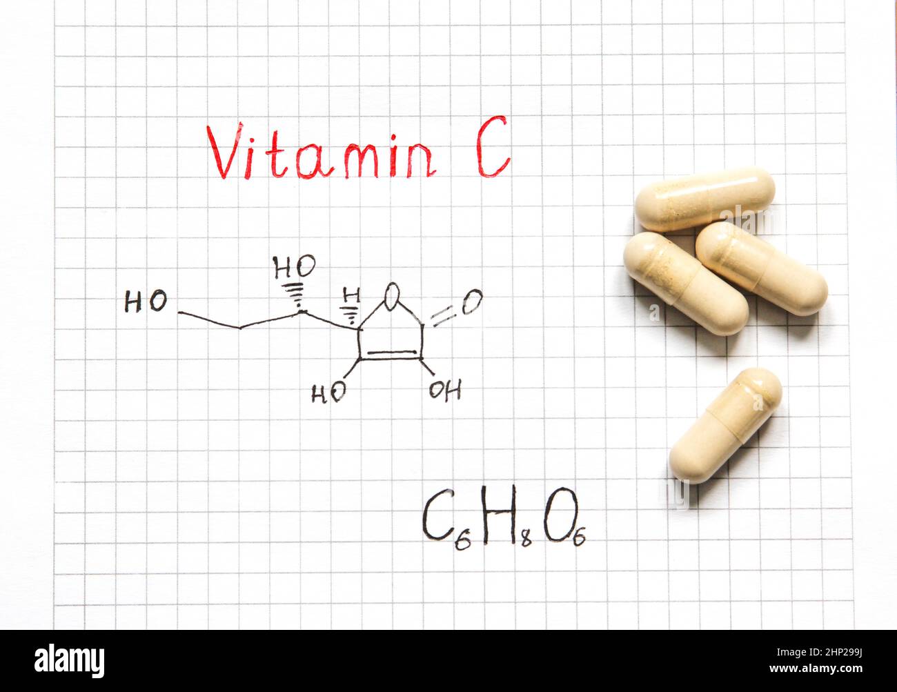 Chemical formula of Vitamin C and some pills on the white paper ...