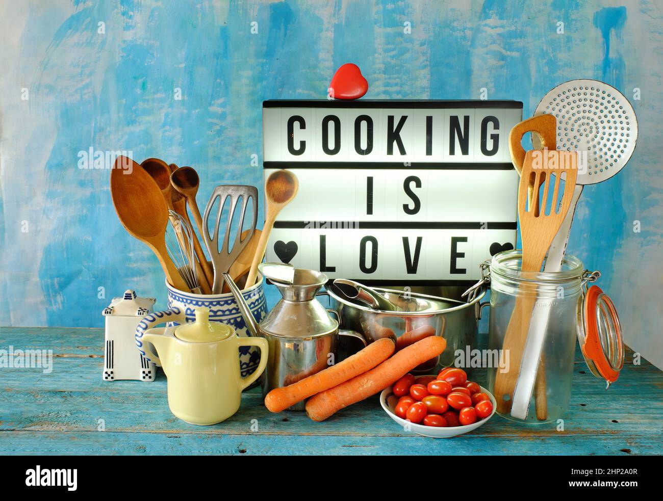various vintage kitchen utensils and sign with "cooking is love ...