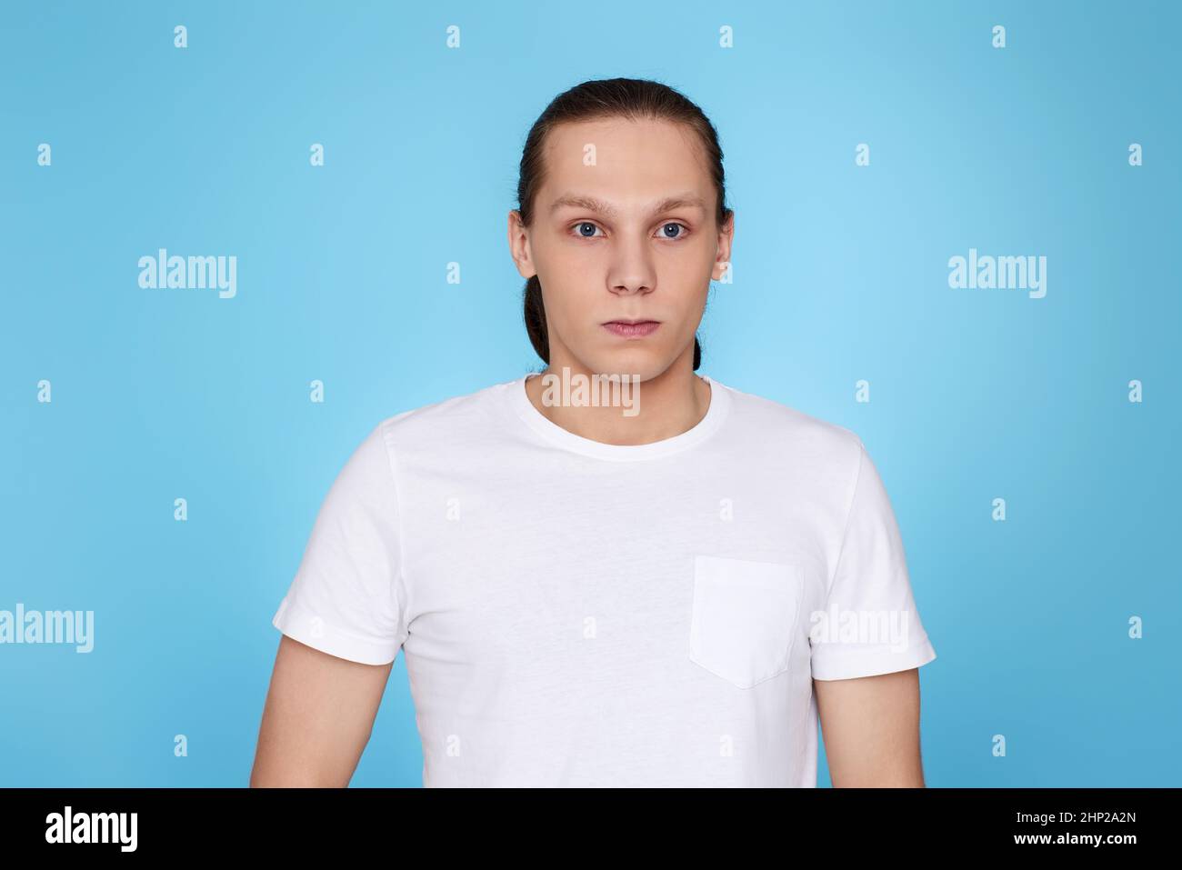 young man frowning isolated on blue background. Human emotions, facial ...