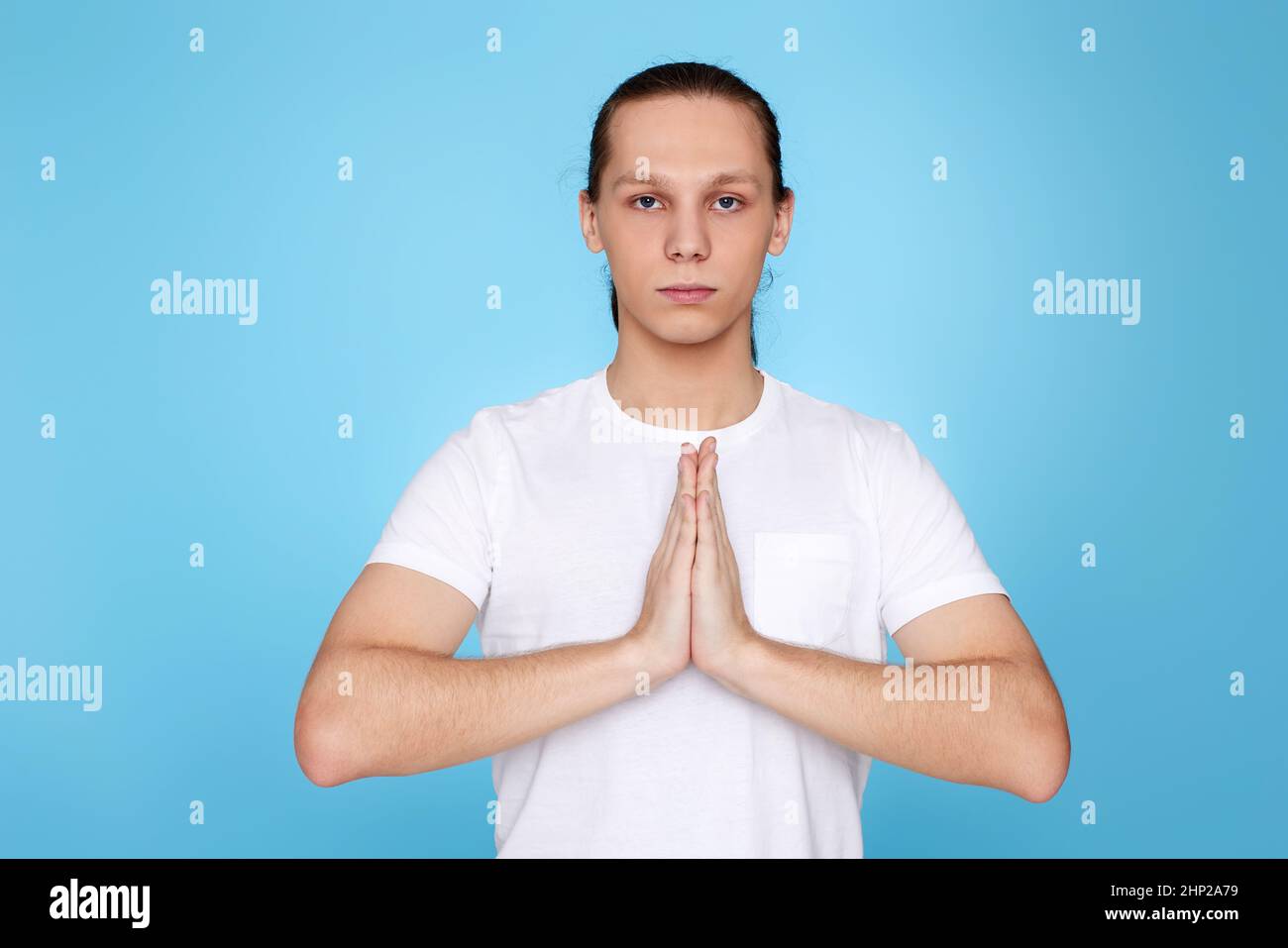 calm man holding hands in yoga gesture, relaxing meditating, trying to ...