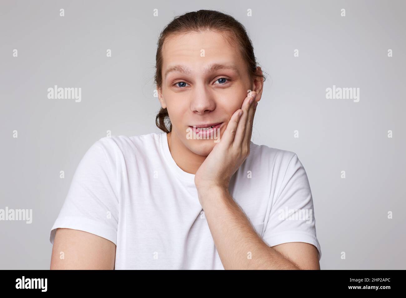 cute shy young handsome man in t-tshirt isolated on gray background ...