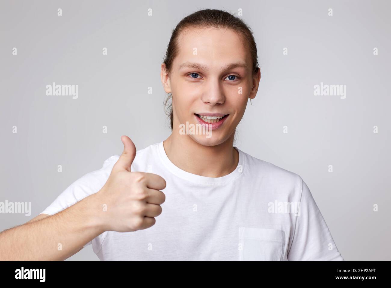 young handsome man in t-tshirt showing Ok gesture isolated on gray ...