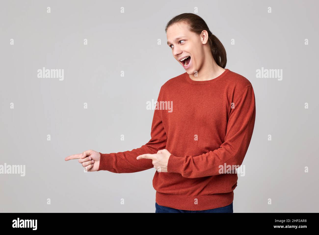 very excited young man pointing finger away at empty space for ...