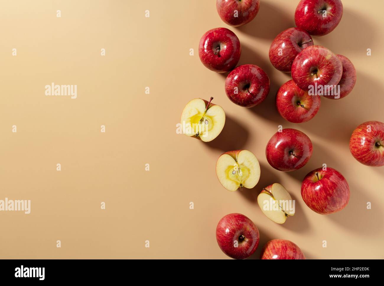 A lot of apples placed on a beige background, cut in half or quarter ...