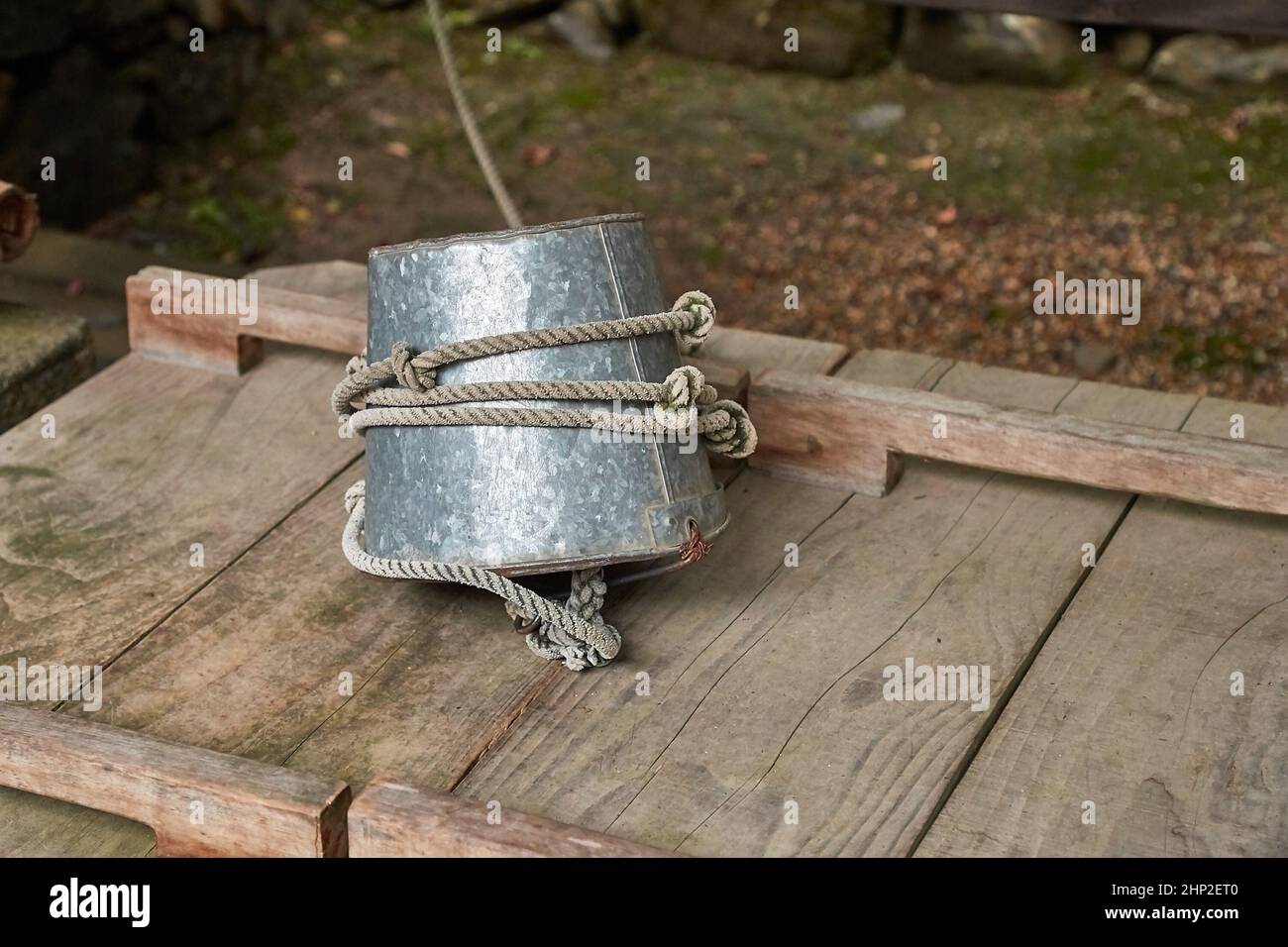 Metal bucket on a rope for a water well Stock Photo - Alamy