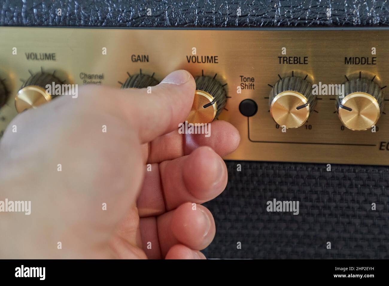 Cable plugged in to a guitar amplifier, adjusting gain and volume Stock ...