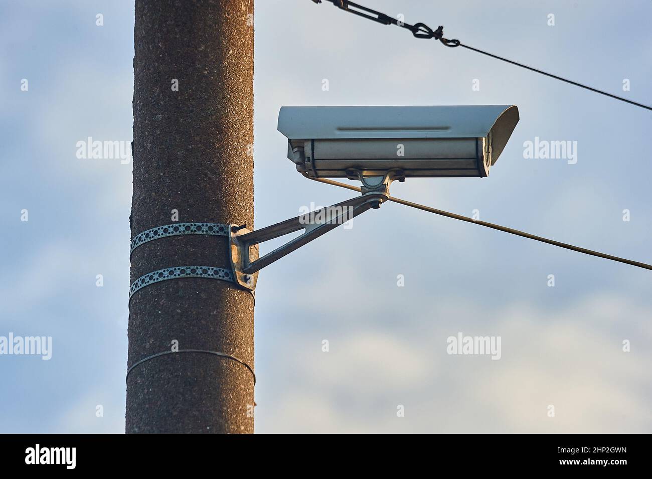 A security camera is hanging on a concrete post. High quality photo ...