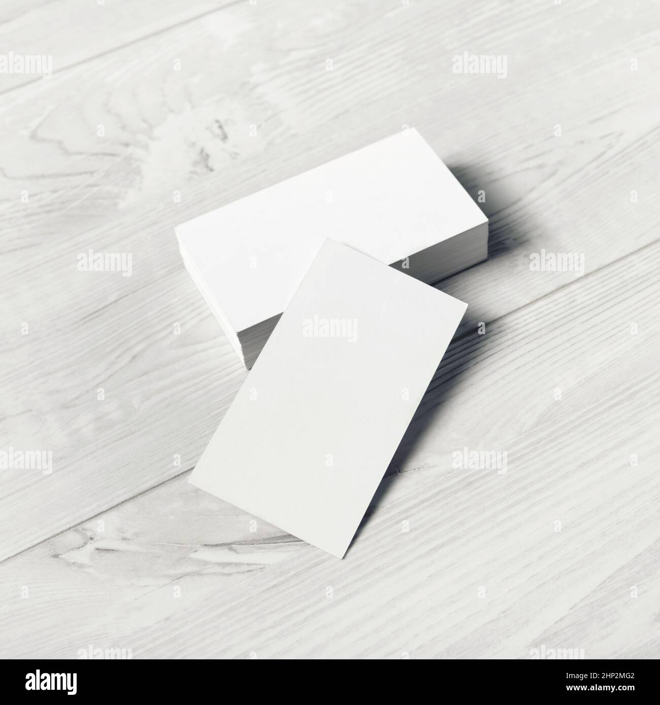 Blank white business cards on light wooden background. Mockup for ID ...