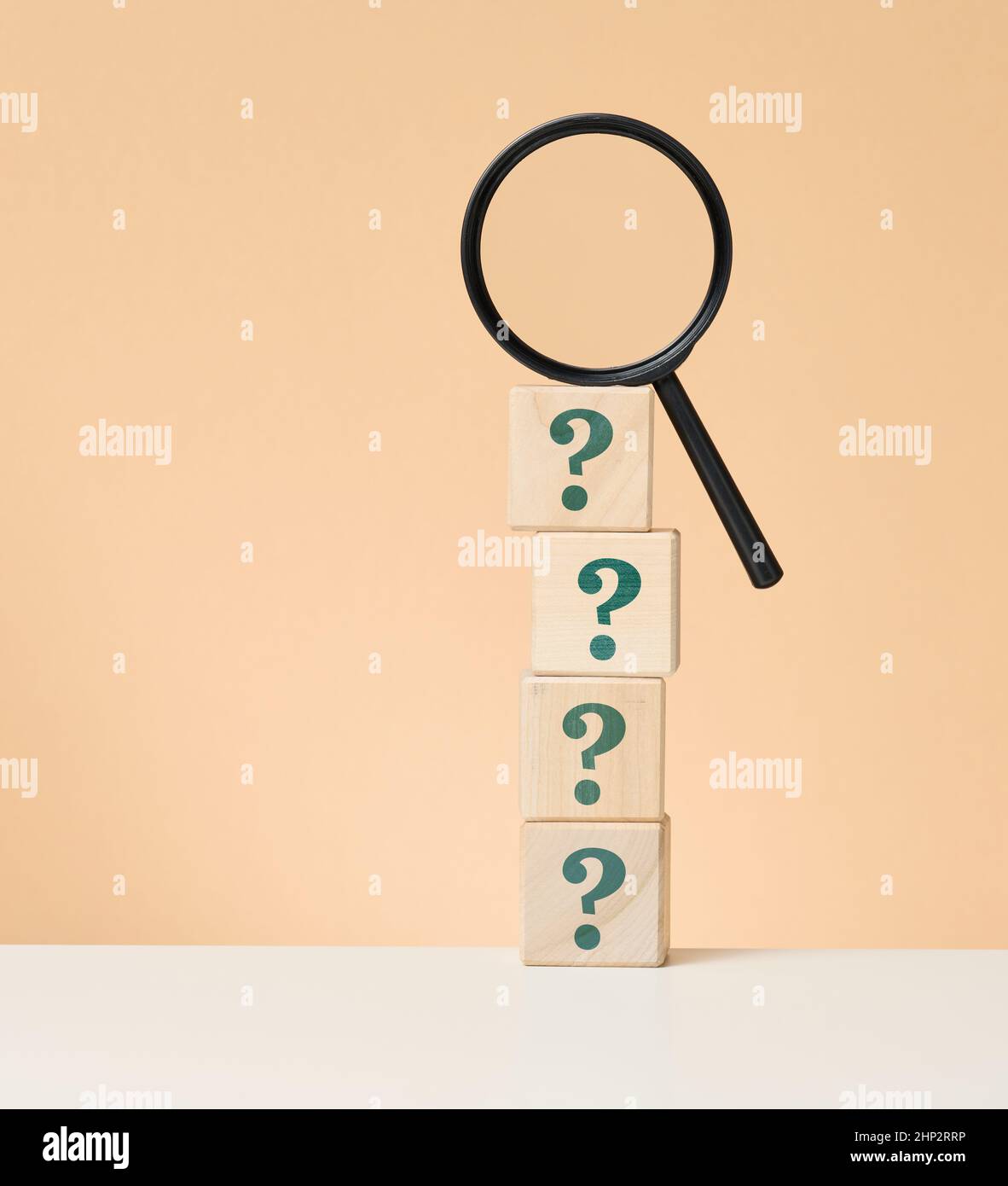 wooden magnifying glass and question marks. The concept of finding an ...