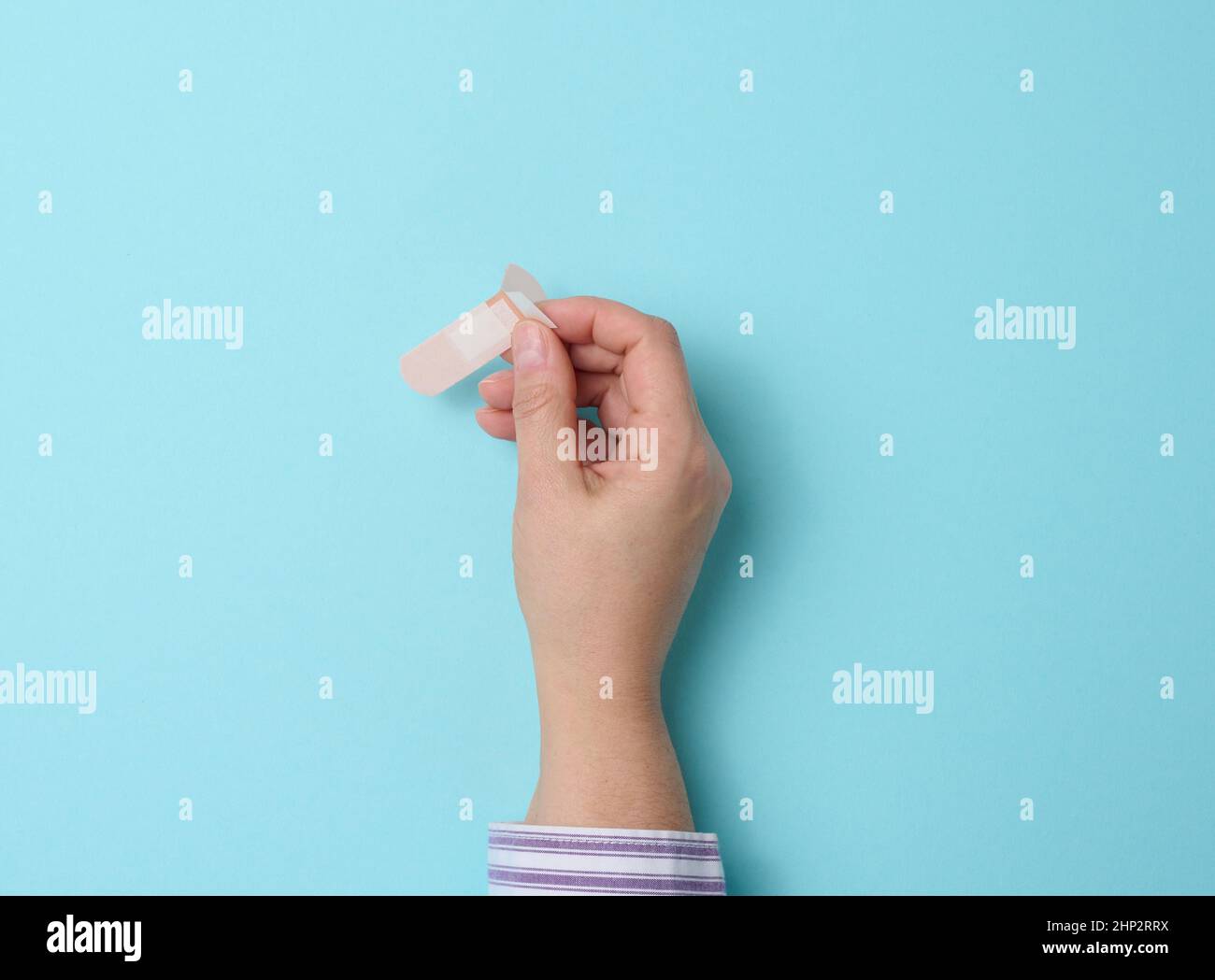 female hand and brown medical adhesive plaster for the treatment of ...