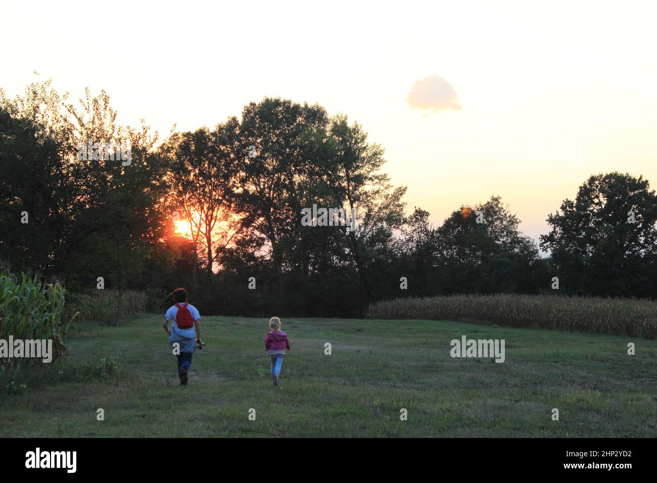 Two kids running in the field at sunset Stock Photo - Alamy