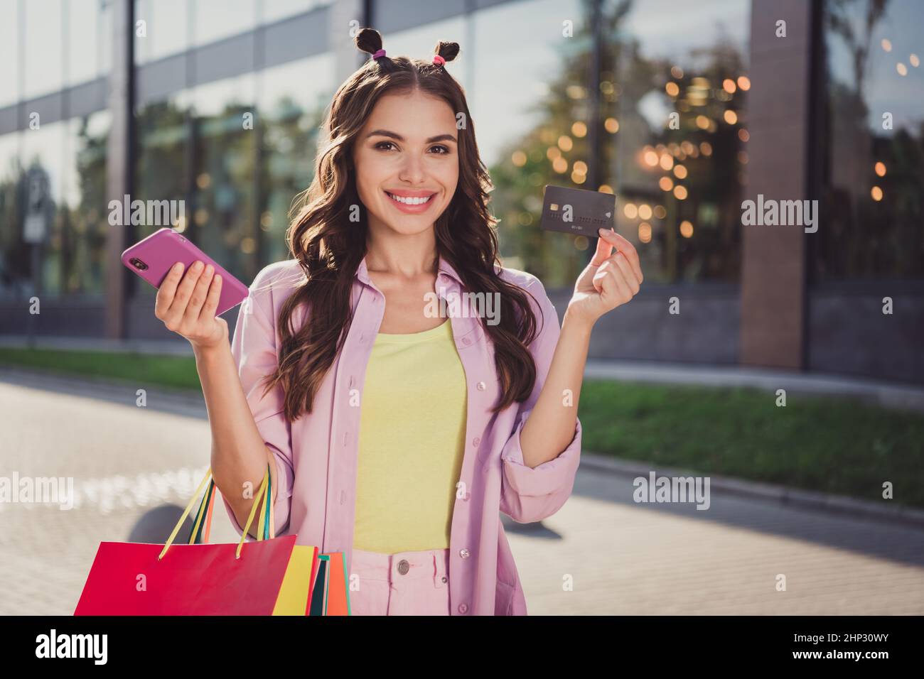 Portrait of beautiful cheerful wavy-haired girl buying clothes using ...