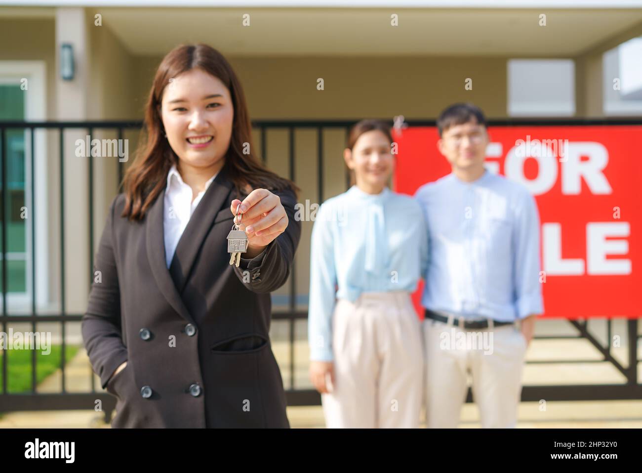 Asian real estate agent or realtor woman smiling and holding red file ...