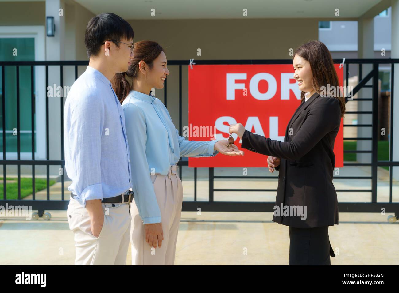 Asian happy smile young couple take keys new big house from real estate ...