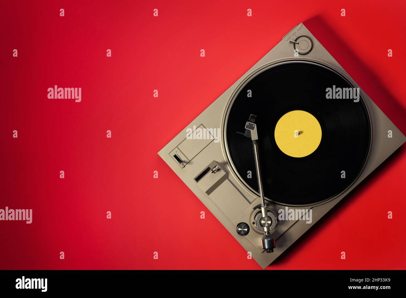 Gramophone with a vinyl record on a red table, top view and copy space ...