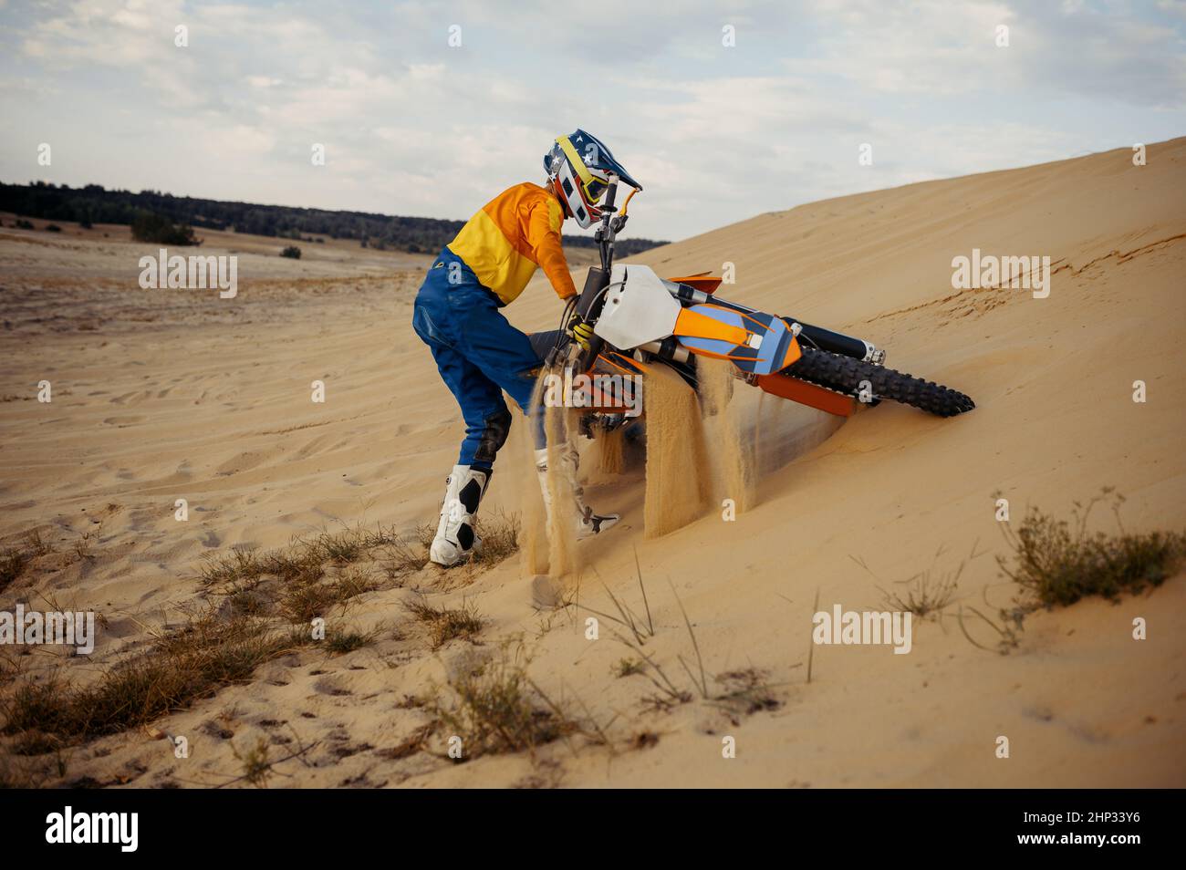 Motocross rider in helmet picking up motorcycle scooter after falling ...