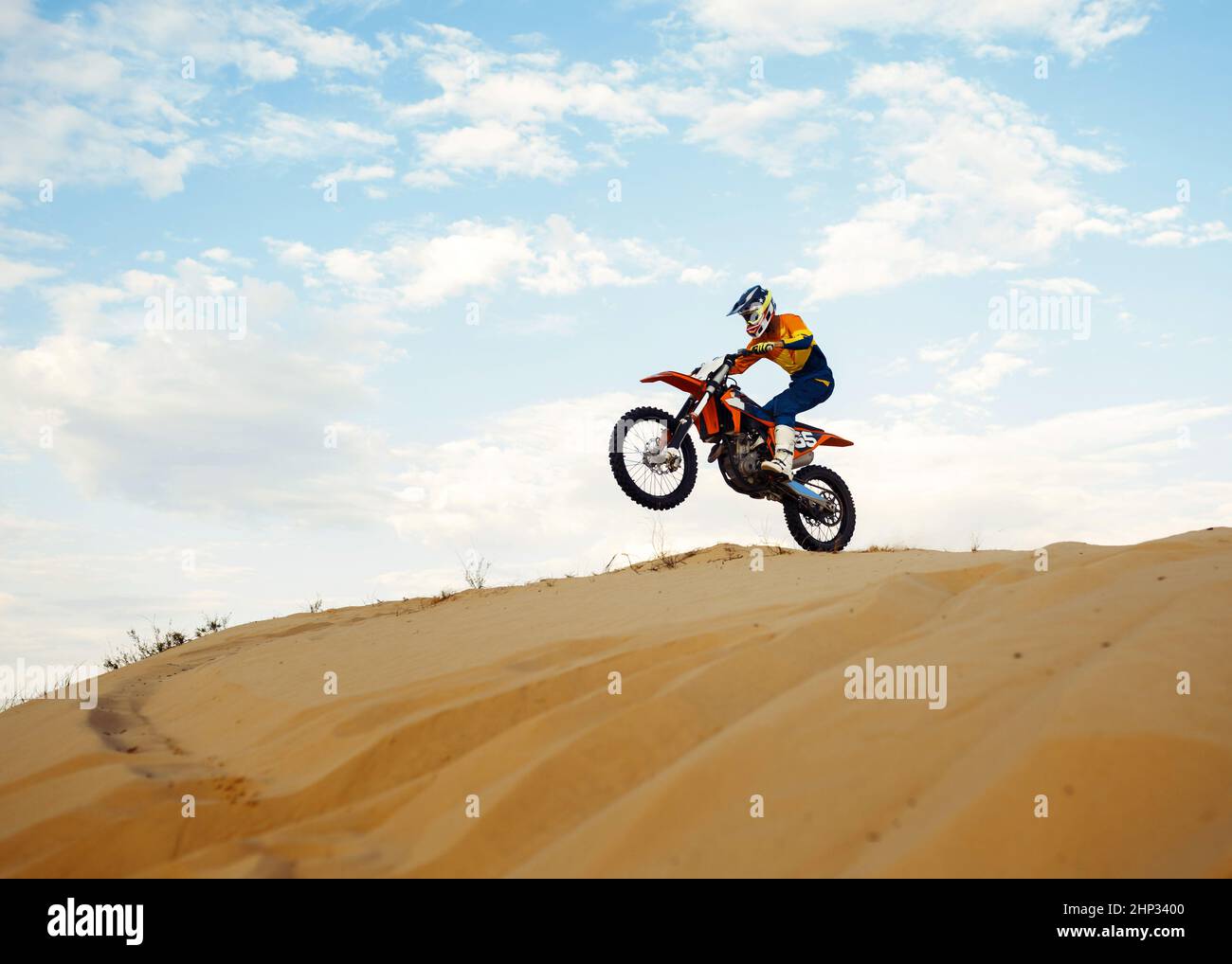 Motorcross riding over sand in desert dune. Professional bike pilot ...
