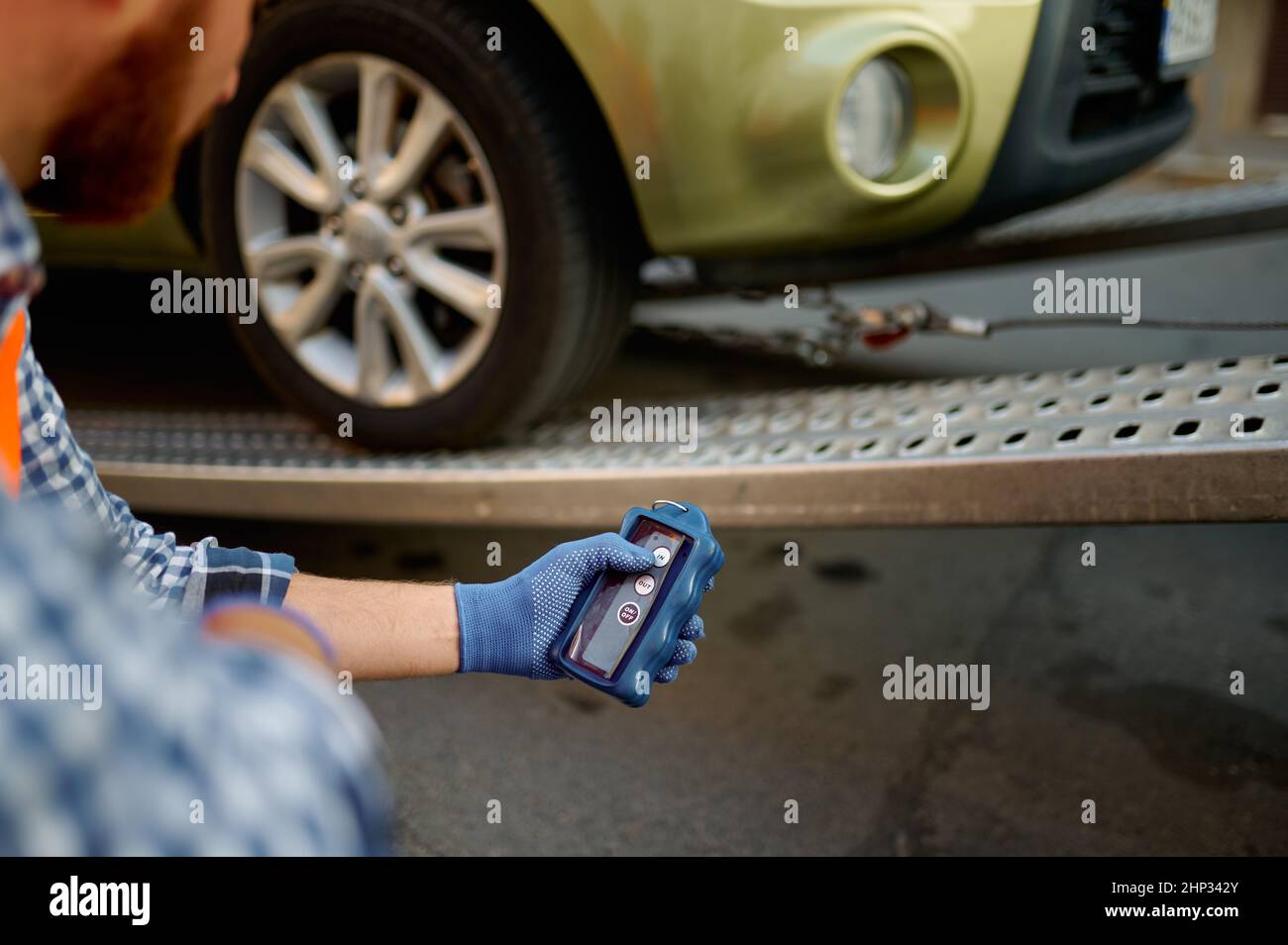 Closeup view on male road worker wearing uniform monitoring car loading ...