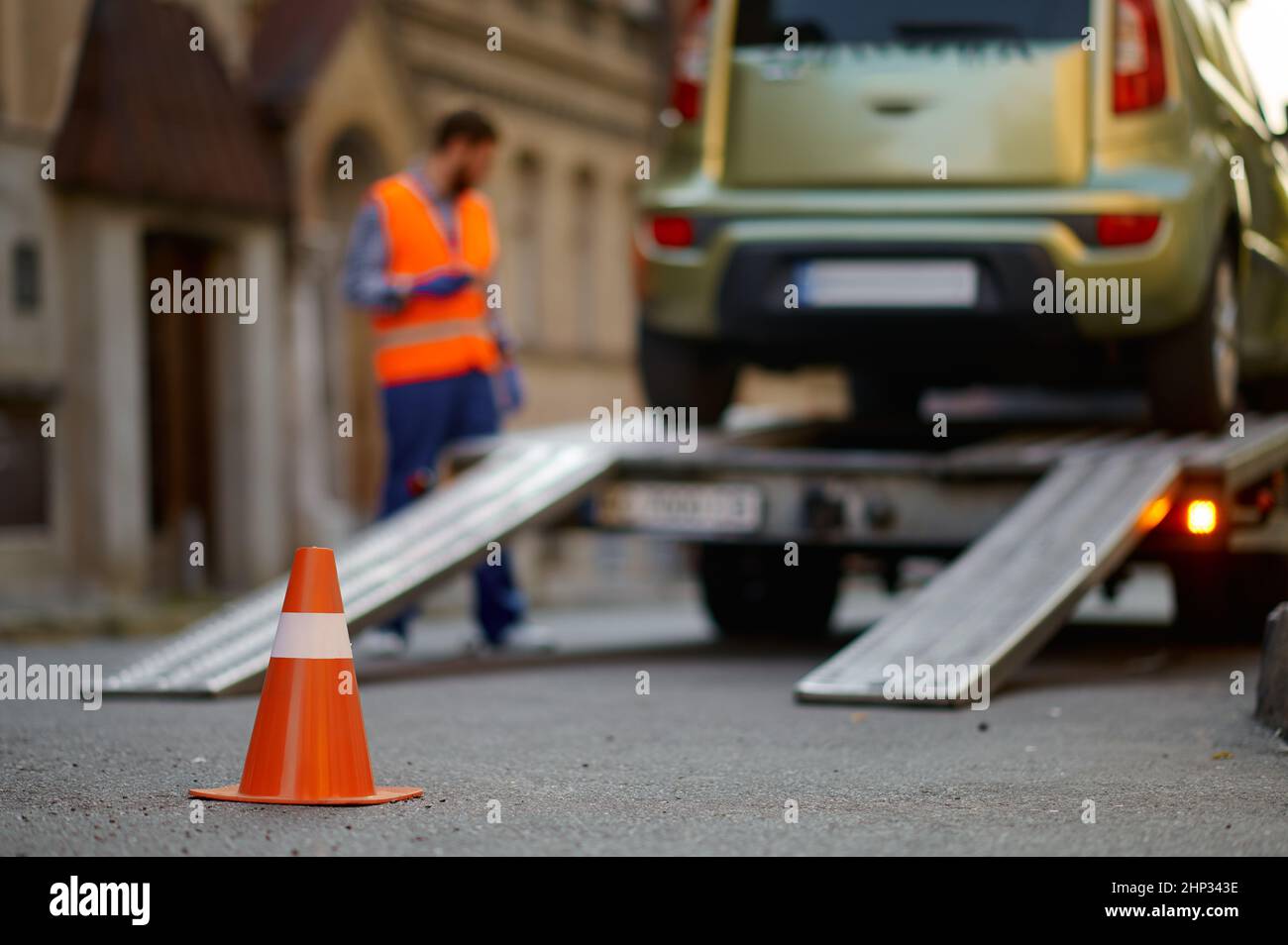 Selective focus on orange traffic road cone standing on asphalt protect ...