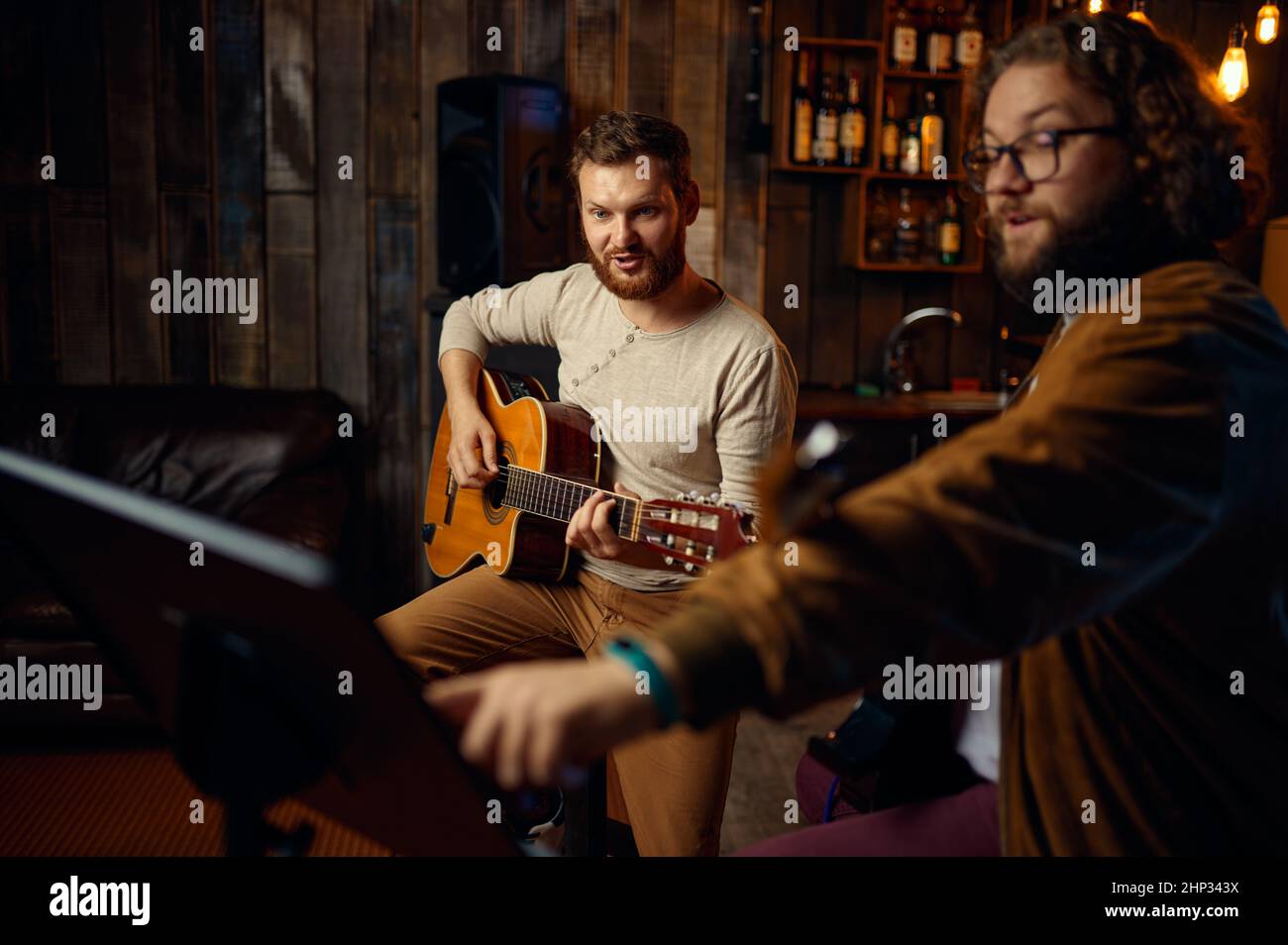 Teacher giving guitar lesson to young guy. Extracurricular activities ...