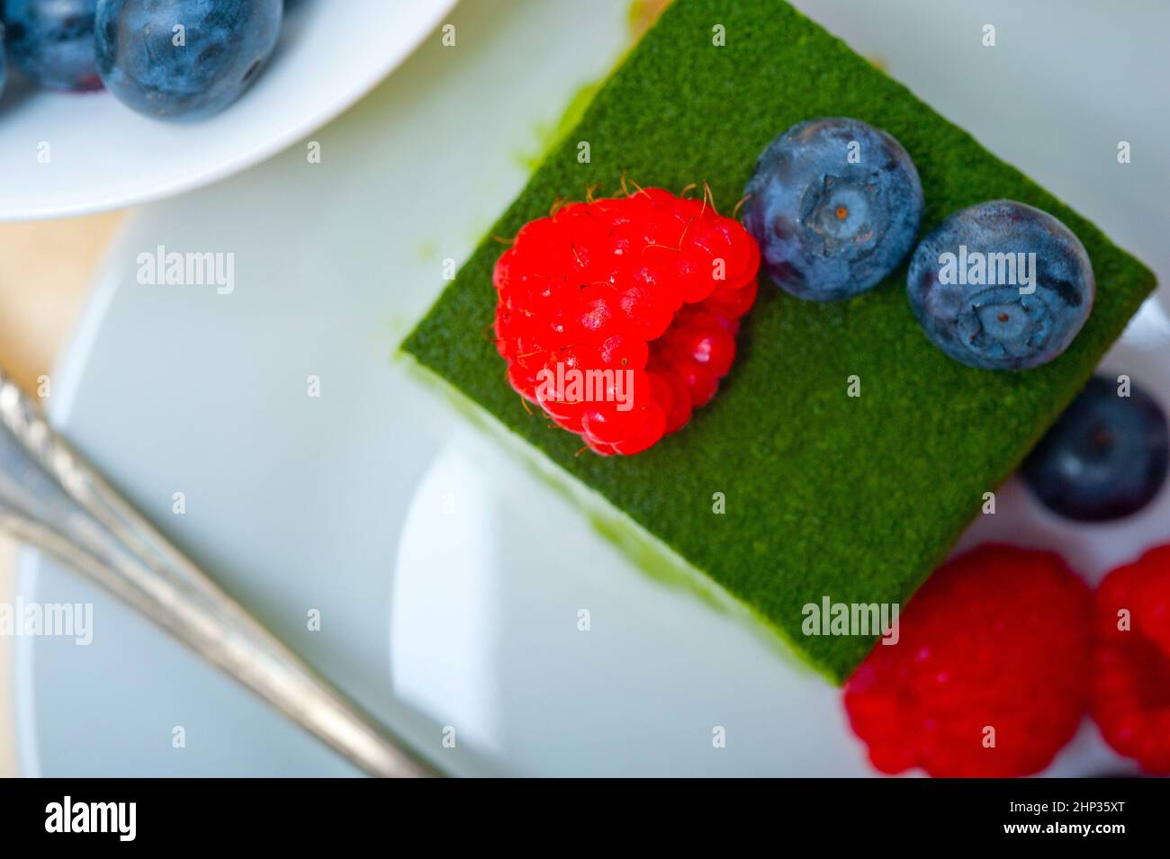 green tea matcha mousse cake with raspberries and blueberries on top ...
