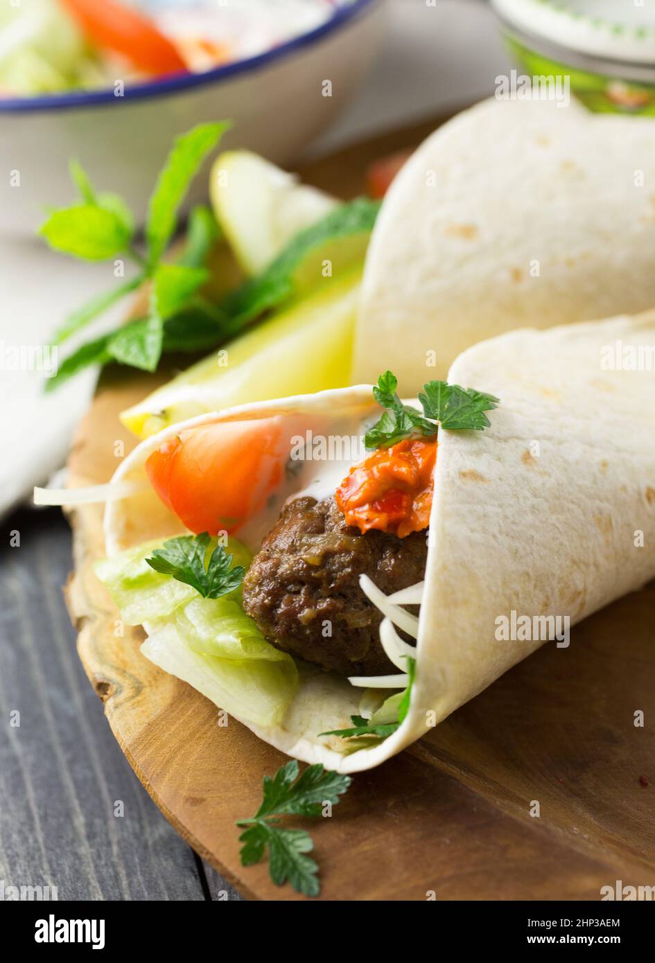 Middle eastern lamb kofta wraps with tomato and yoghurt served on a ...