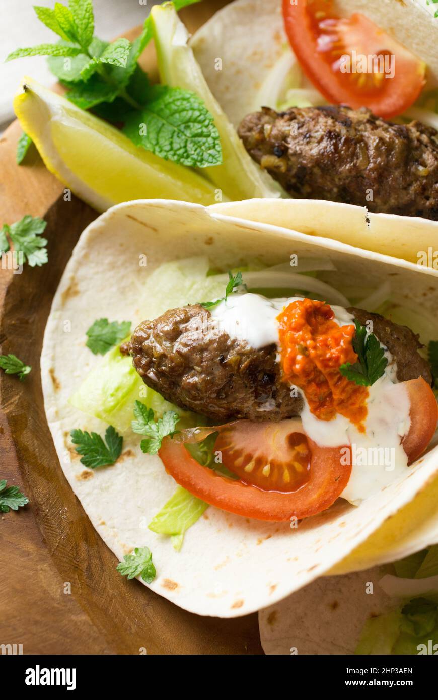 Middle eastern lamb kofta wraps with tomato and yoghurt served on a ...