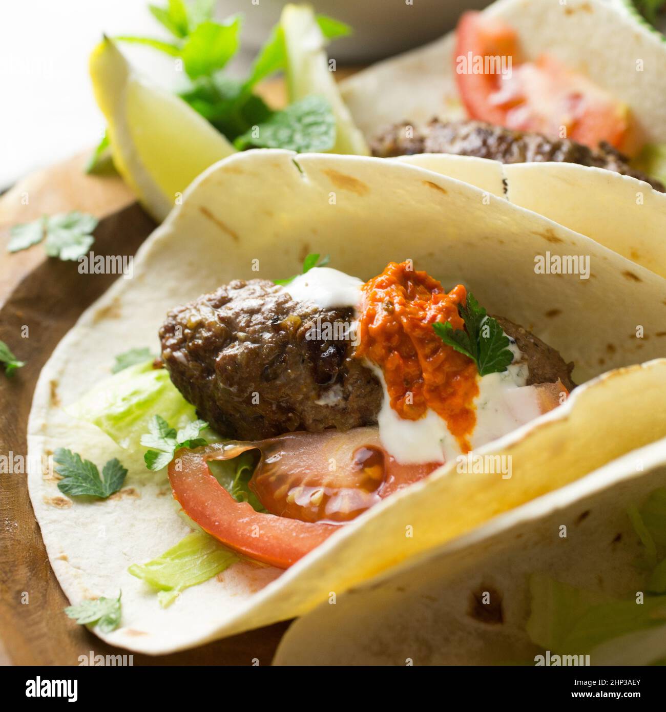 Middle eastern lamb kofta wraps with tomato and yoghurt served on a ...