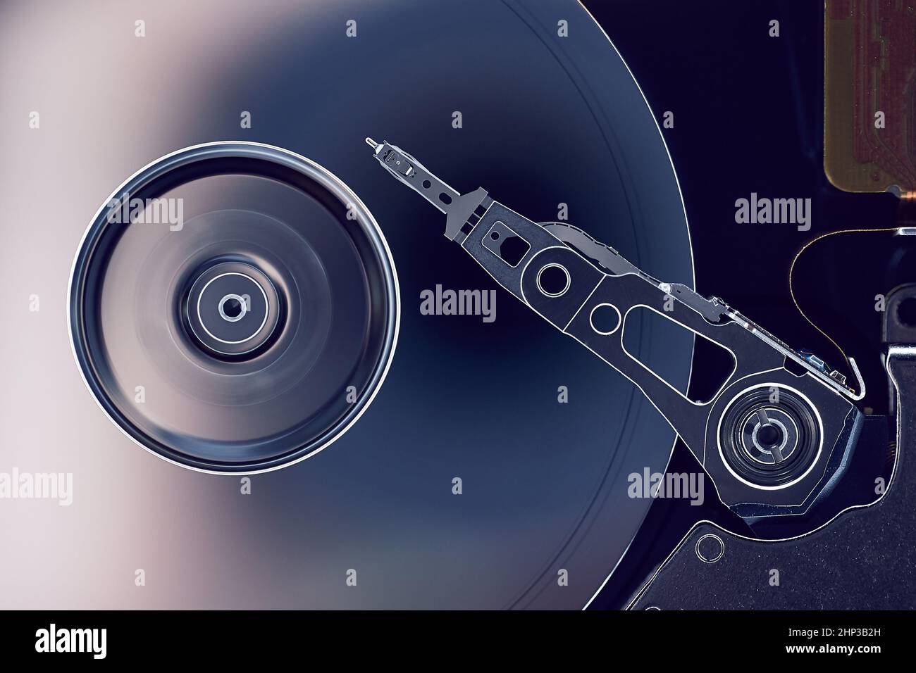 Spinning hard drive disks and writing head macro photo illuminated from ...