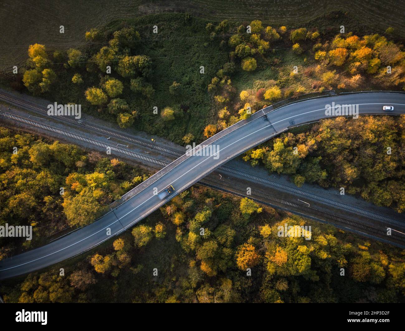 Winding road in autumn forest at sunset in mountains. Aerial view. Top ...