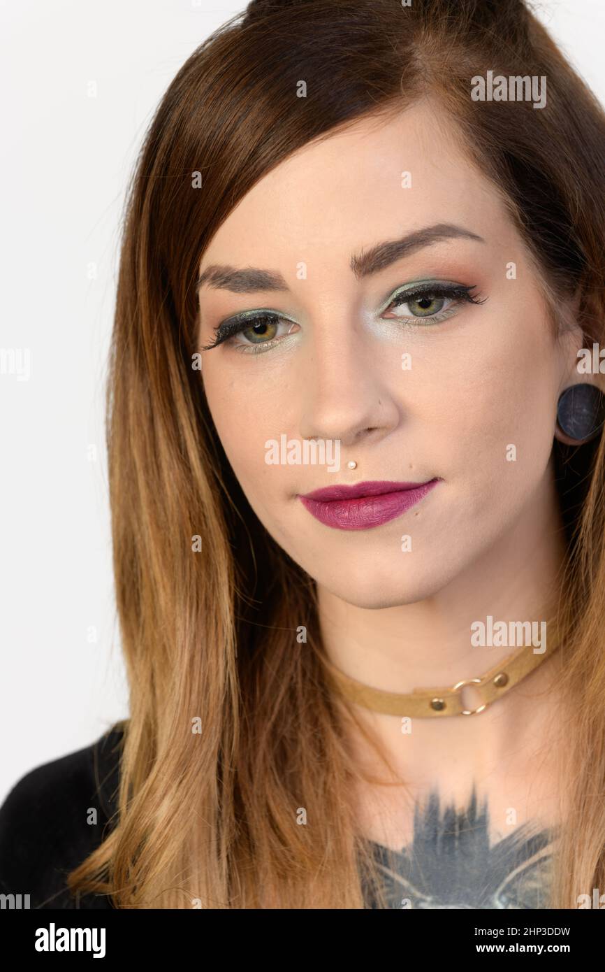 Portrait close-up of a pretty young and intensely made-up woman with a ...
