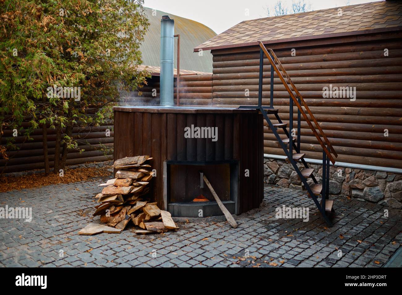 Wooden steaming bathtub with stove and ladder on outside terrace in ...