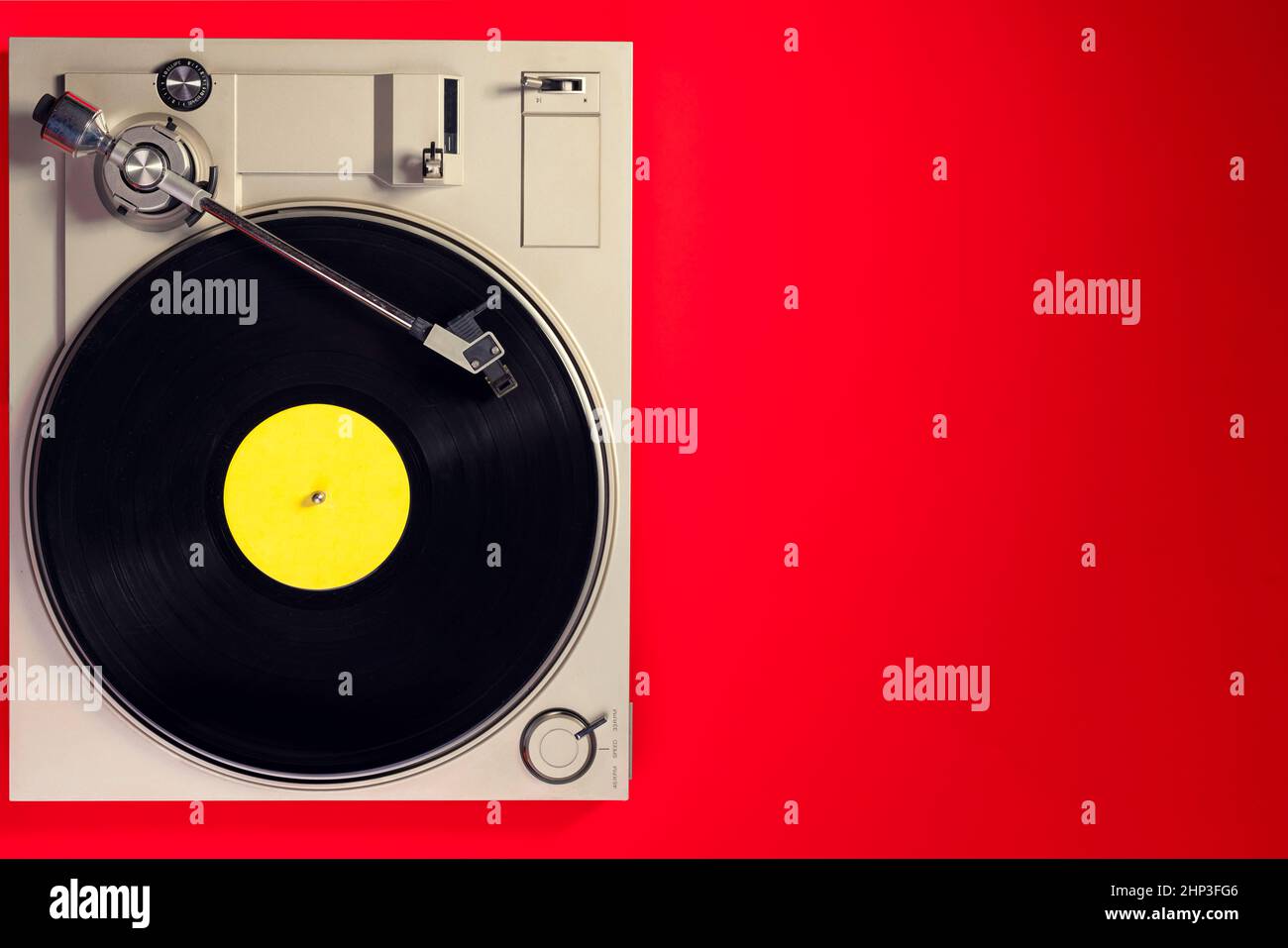 Gramophone with a vinyl record on a red table, top view and copy space ...