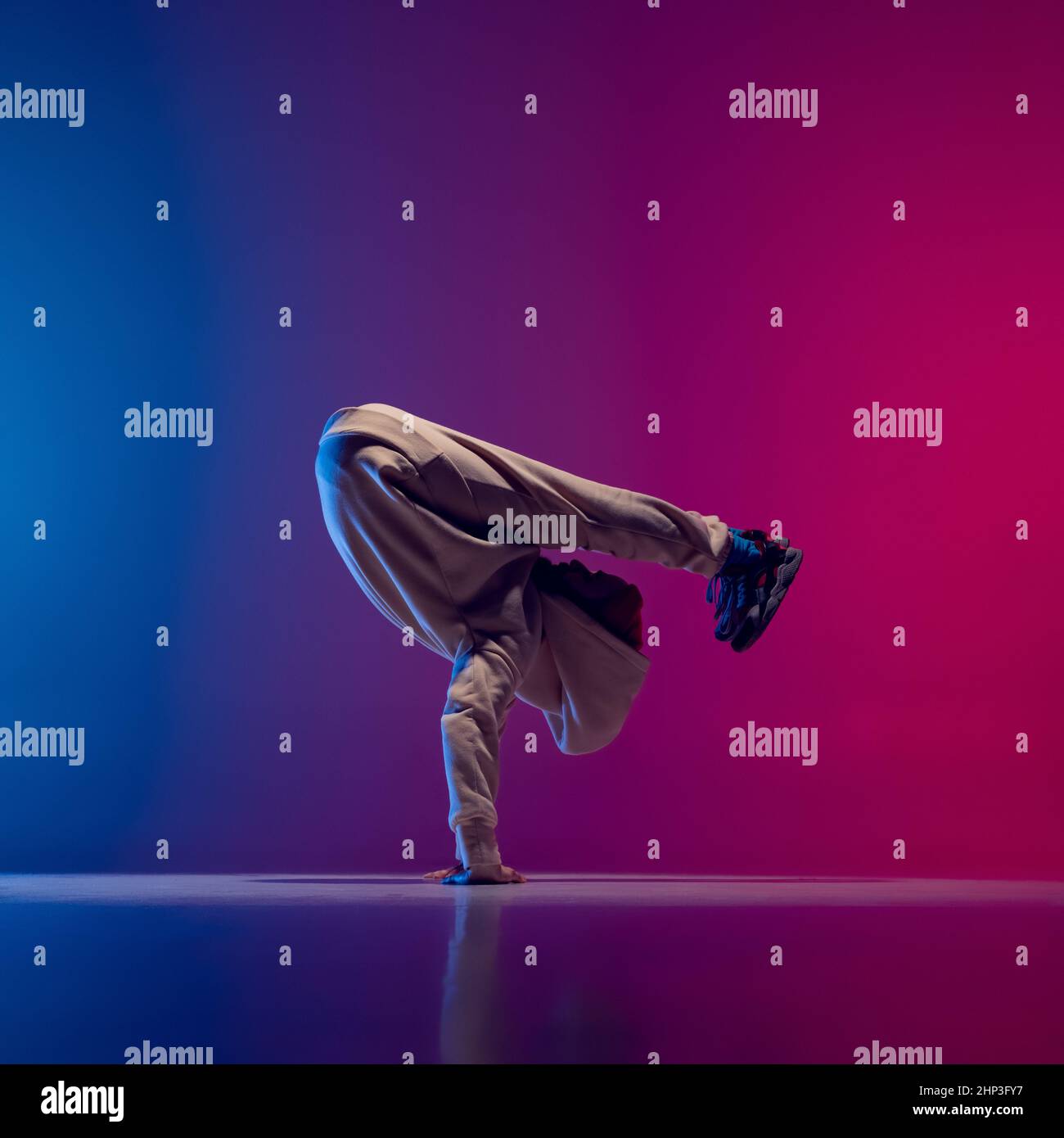 Studio shot of young flexible sportive man dancing breakdance in white ...