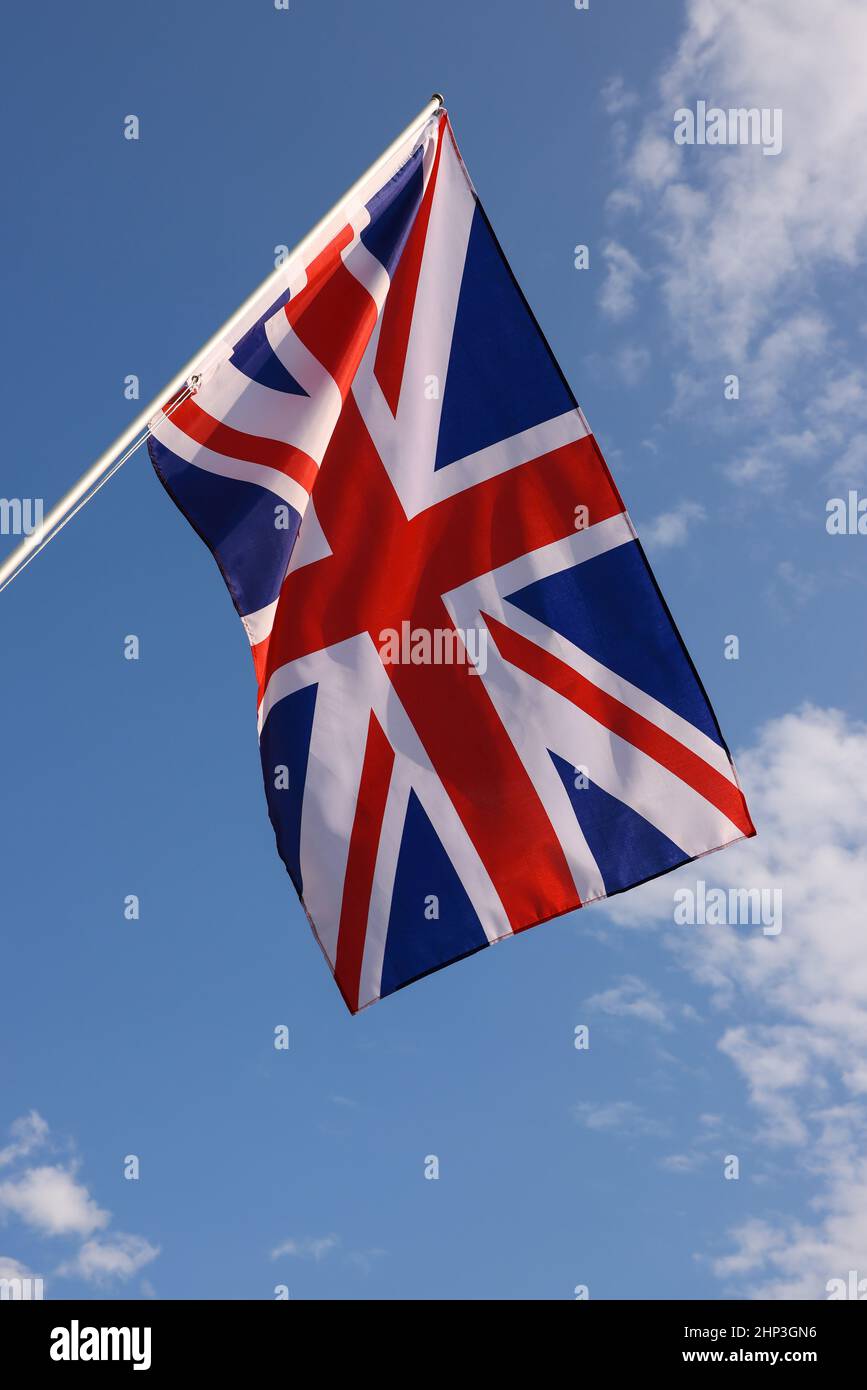 UK Great Britain national flag hanging on flagstaff over cloudy blue ...