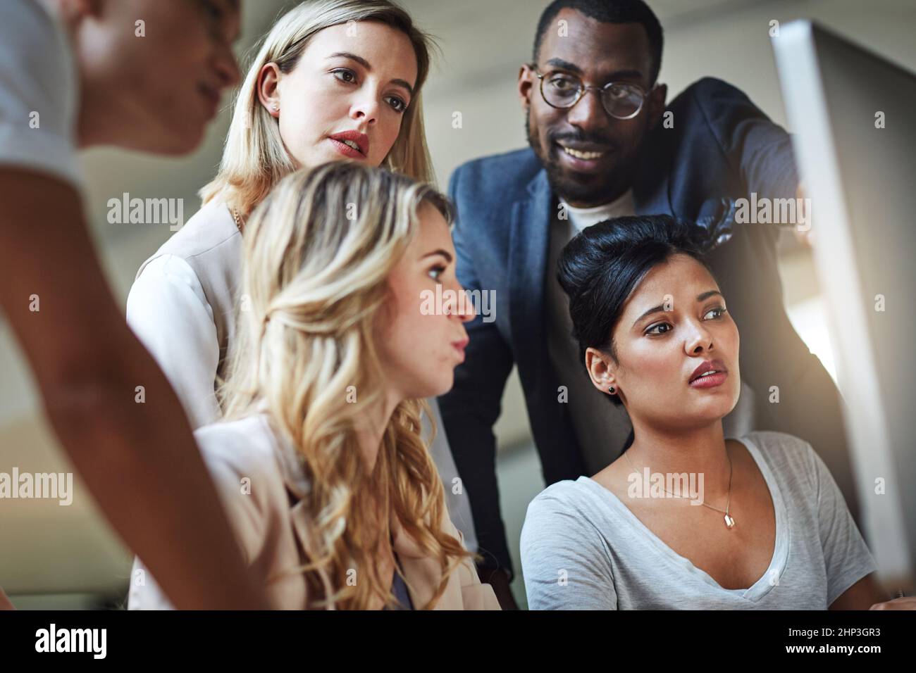 Problem solving done as a unit. Shot of a group of colleagues using a ...