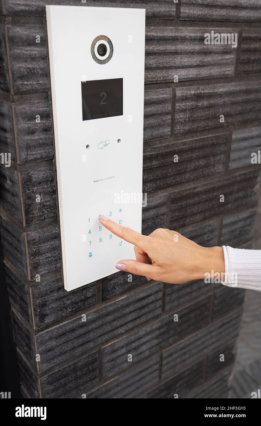 Door Access Control - A young woman enters a code to open the door ...