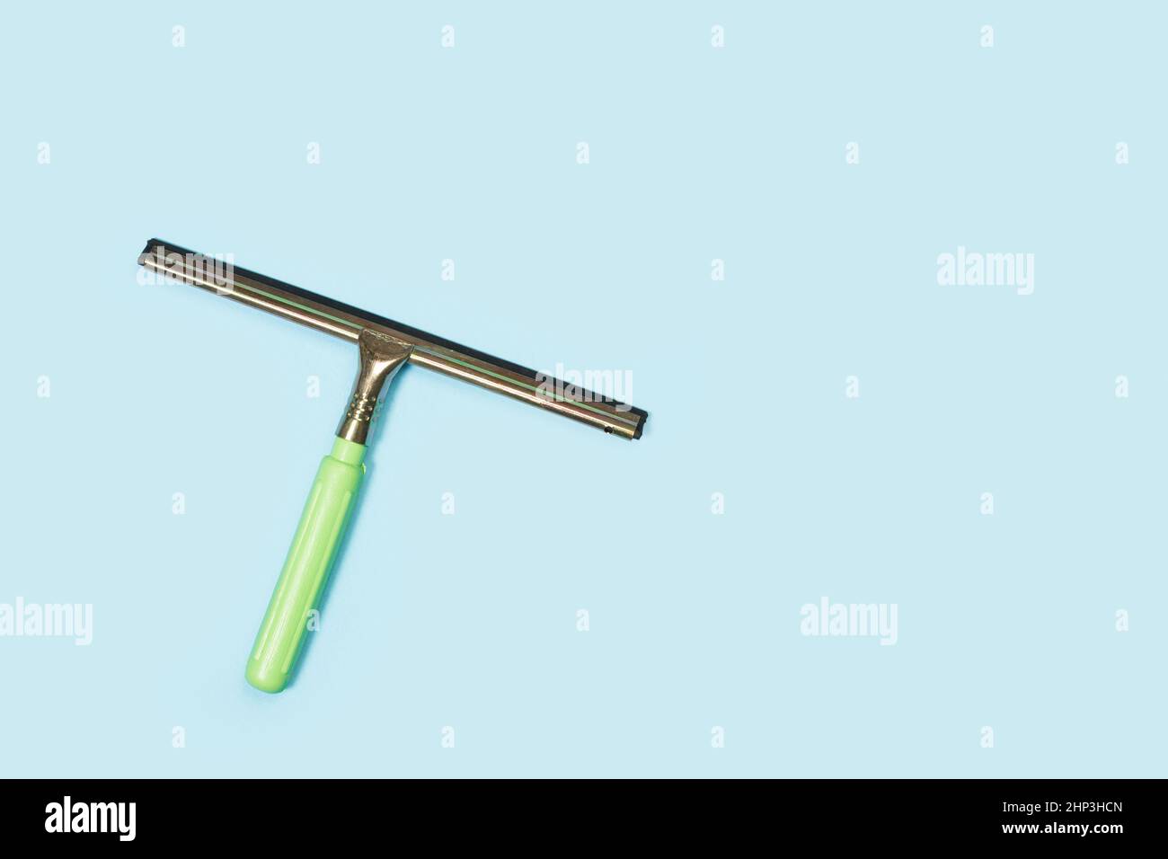 A hand held squeegee on a light blue background with copy space Stock ...