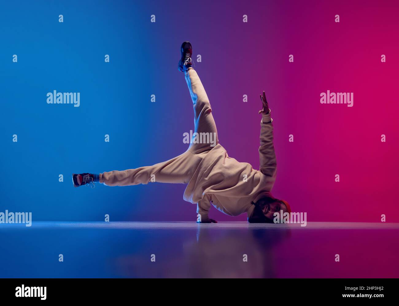Studio shot of young flexible sportive man dancing breakdance in white ...