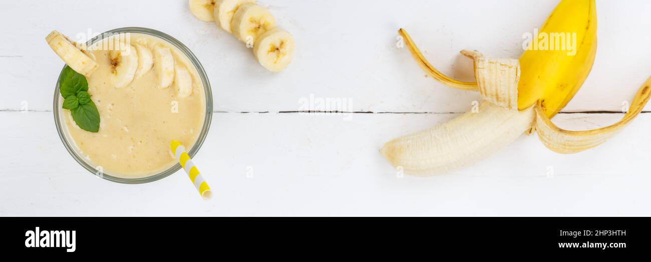 Banana fruit juice smoothie fresh drink in a glass from above panorama ...