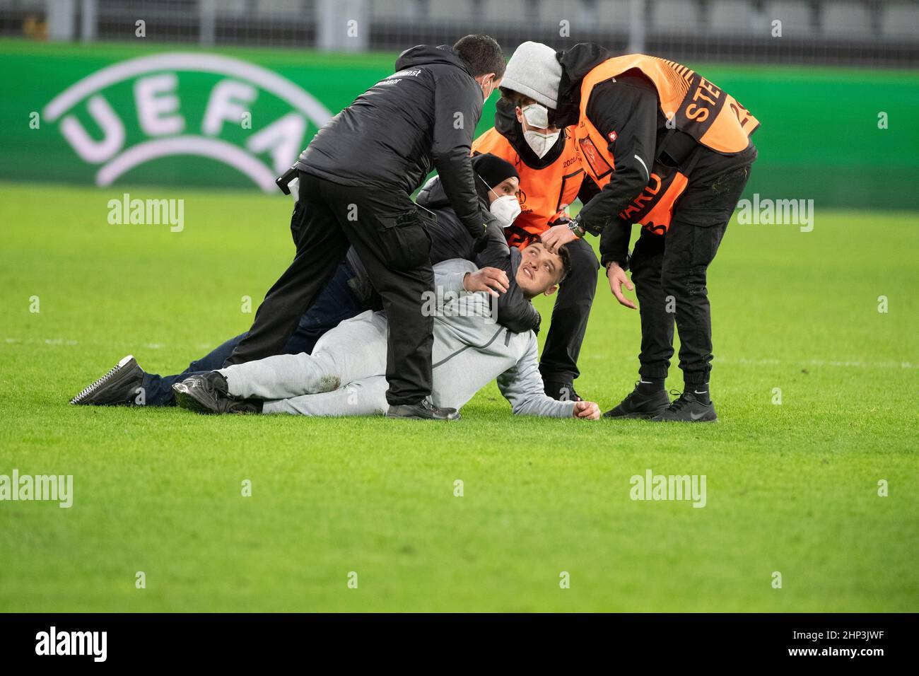 A streaker runs across the pitch and is caught by folders and carried ...
