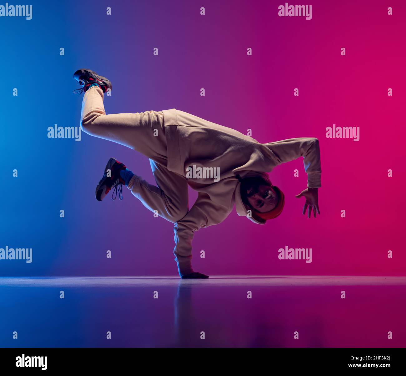 Studio shot of young flexible sportive man dancing breakdance in white ...