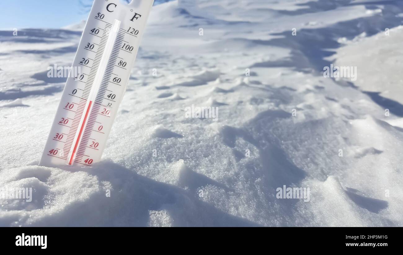 The thermometer lies on the snow and shows a negative temperature in ...