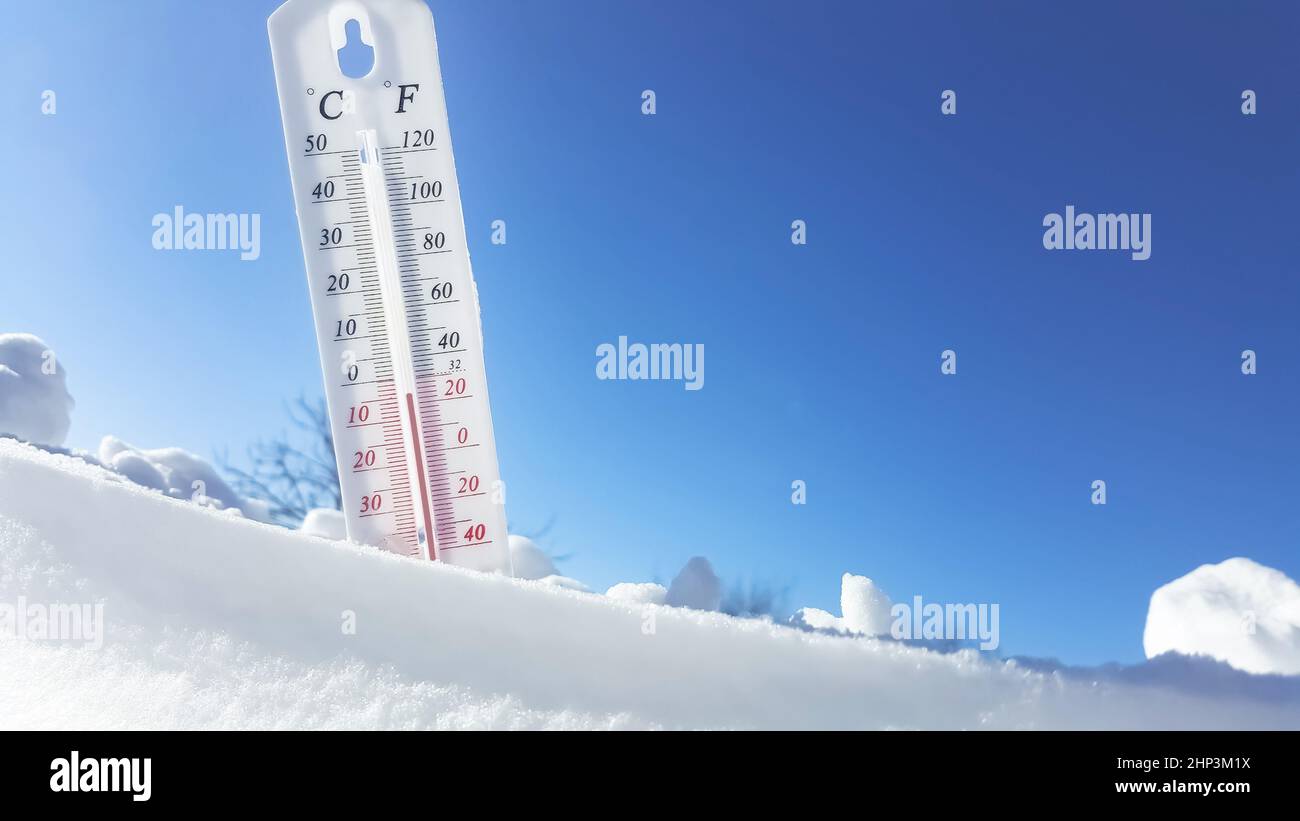 The thermometer lies on the snow and shows a negative temperature in ...