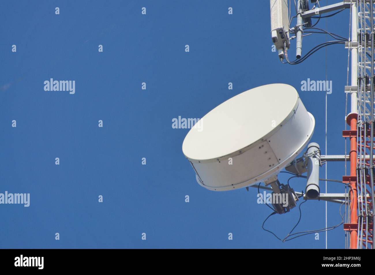 Internet towers and transmission equipment on clean blue sky background ...