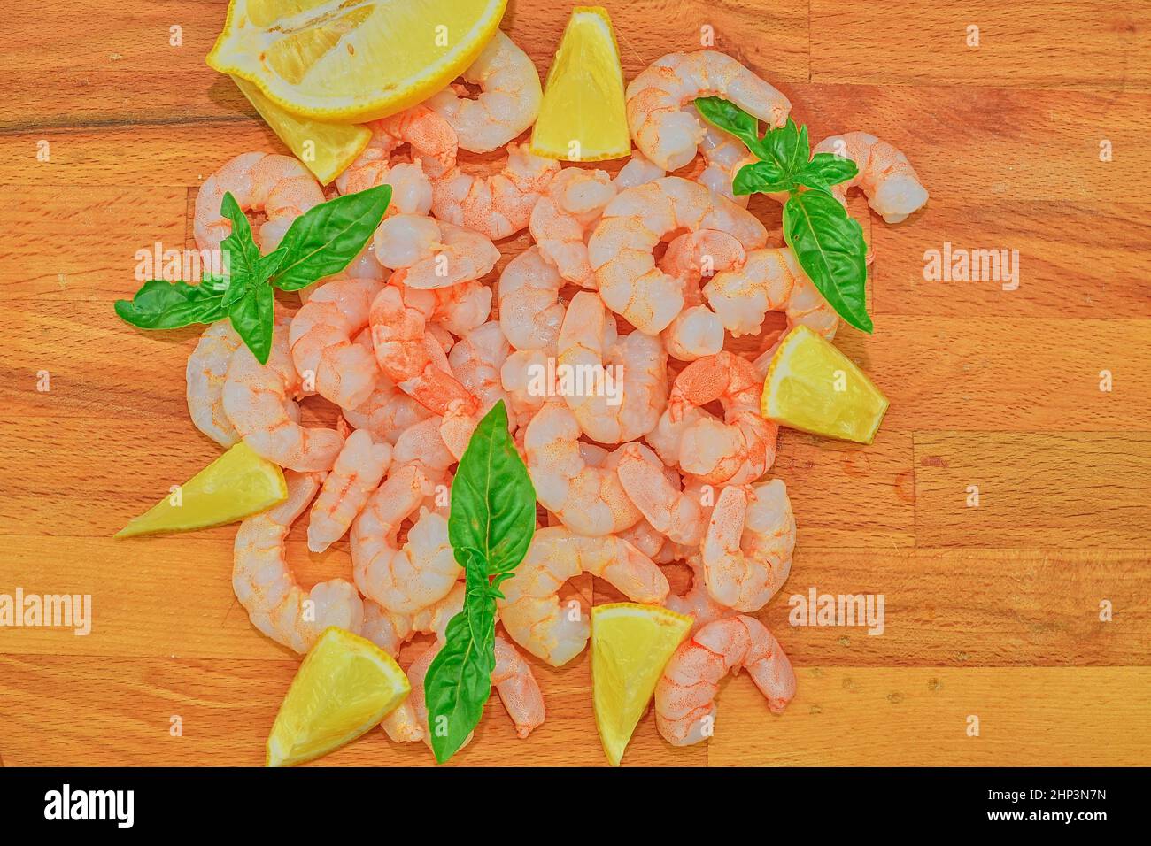 Cooked and peeled prawns with slices of lemon and leaves of basil on ...