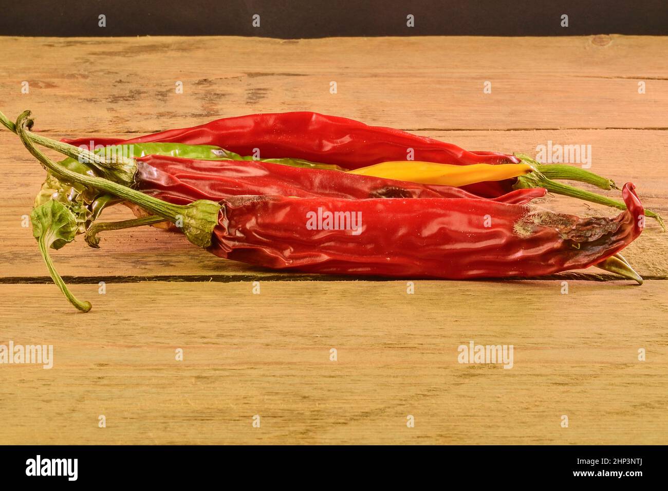 Shrinking and mould chili peppers on white wooden background. Rotten ...