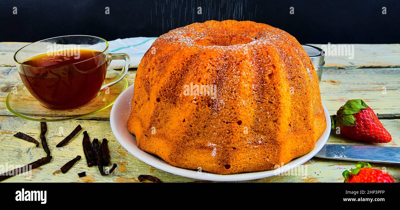 Old fashioned sand cake with cup of black tea and pieces of vanilla on ...